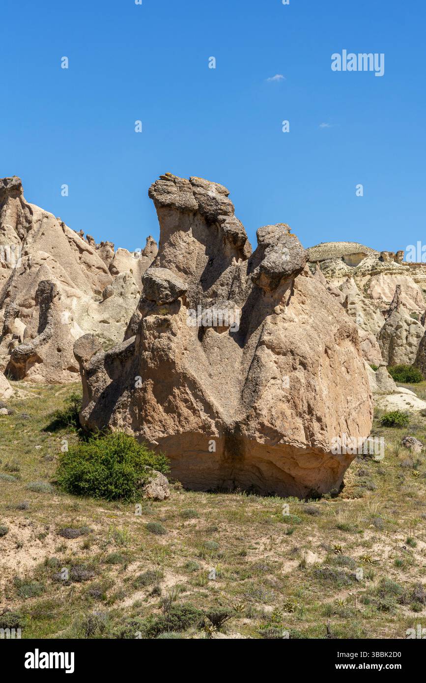 A tall, narrow rock formation with a pointed tip stands among other ...