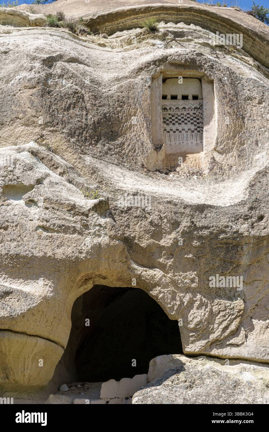 A small arched doorway and window are carved into the rock face of Big ...