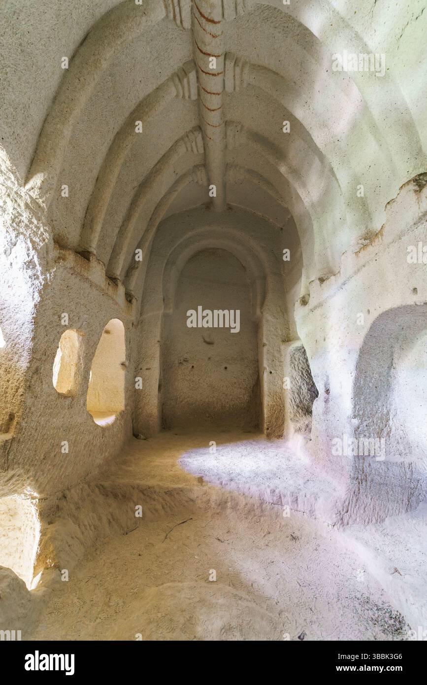 A large arched chamber with carved columns and soft light fills the ...