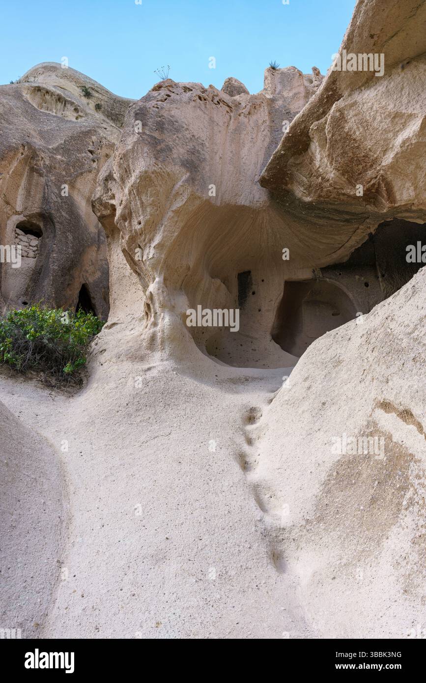 A rock-cut chamber with arched entrances and niches is carved into the ...