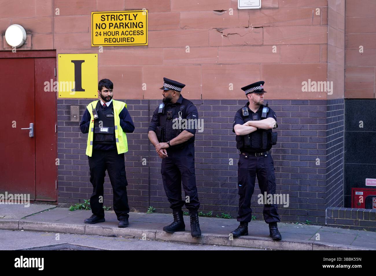 Police officers and security at the rear entrance of Manchester ...