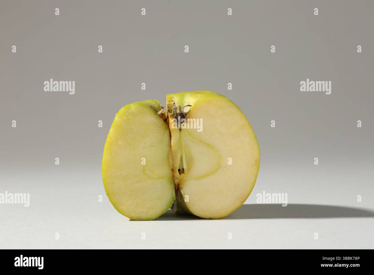 Half of damaged apple on light grey background Stock Photo - Alamy