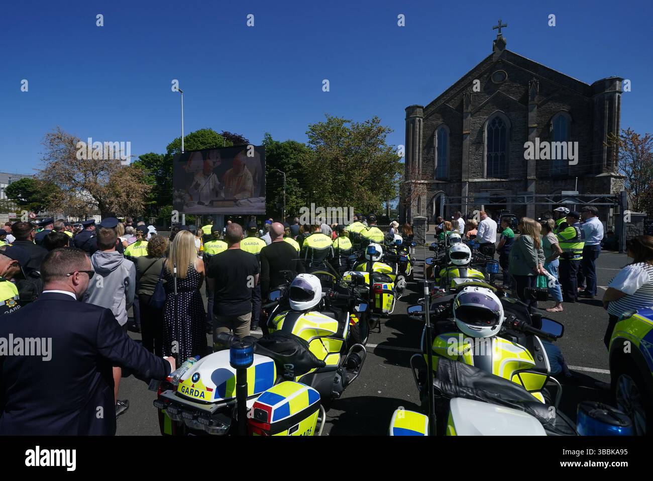 Members of the public and gardai watch the funeral service of Garda ...