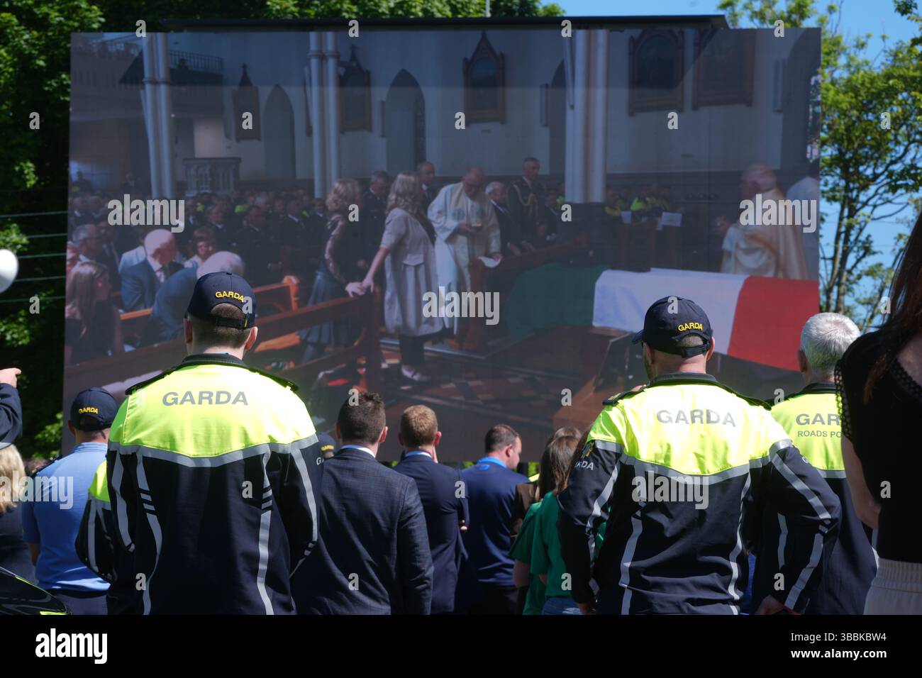 Members of the public and gardai watch the funeral service of Garda ...