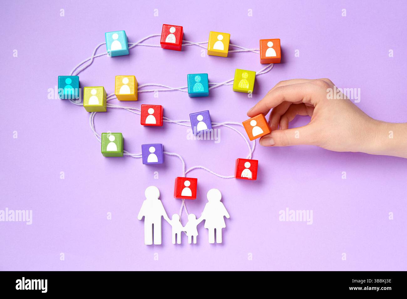 Woman putting cube with human icon to composition of other cubes, rope ...