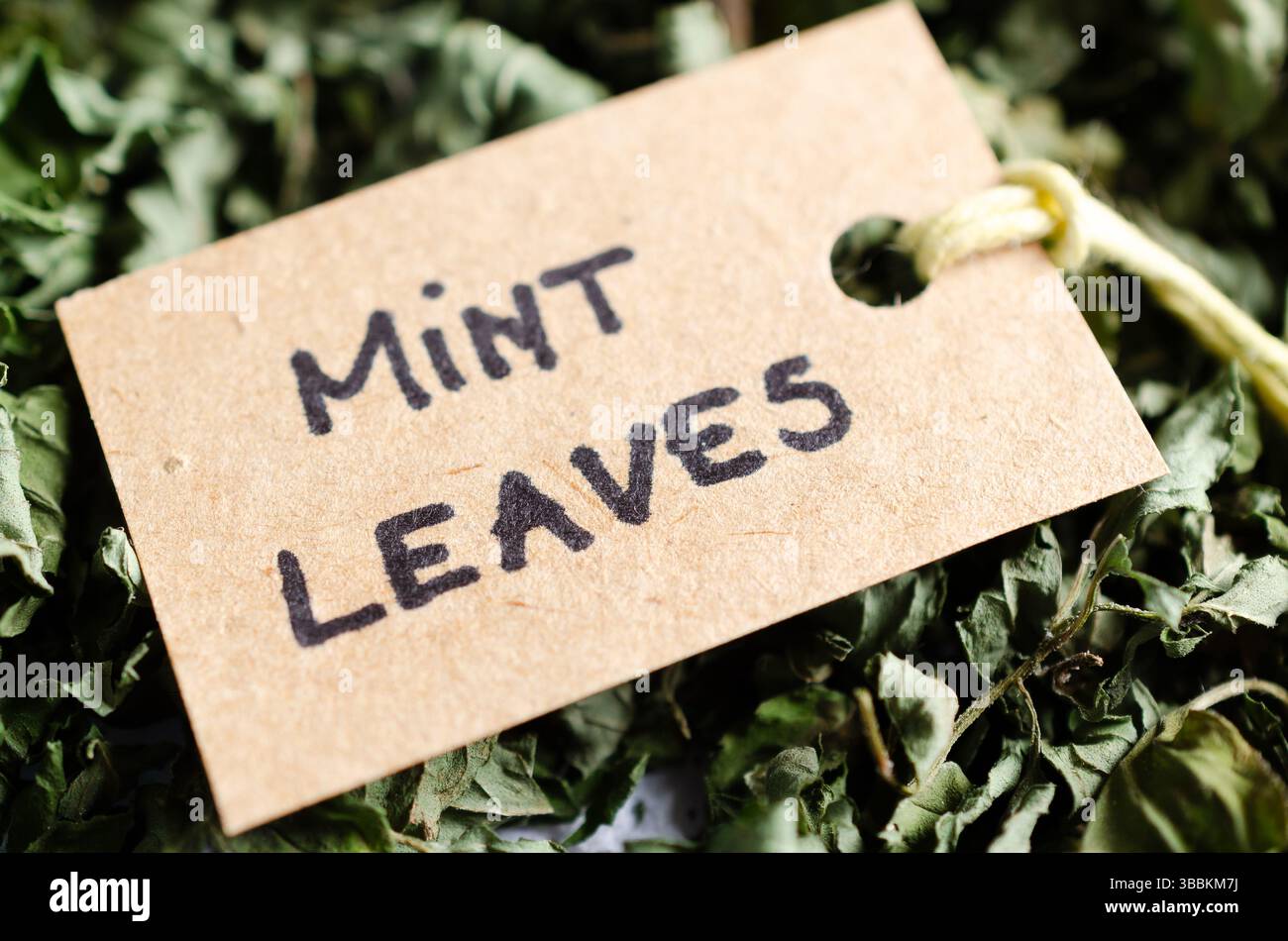 Dried mint leaves with a label in recycled paper written in English ...