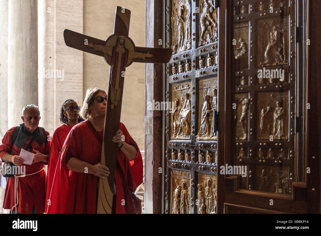 Jubilee Saint Peters Basilica - Holy door Pilgrims hold a cross as they ...