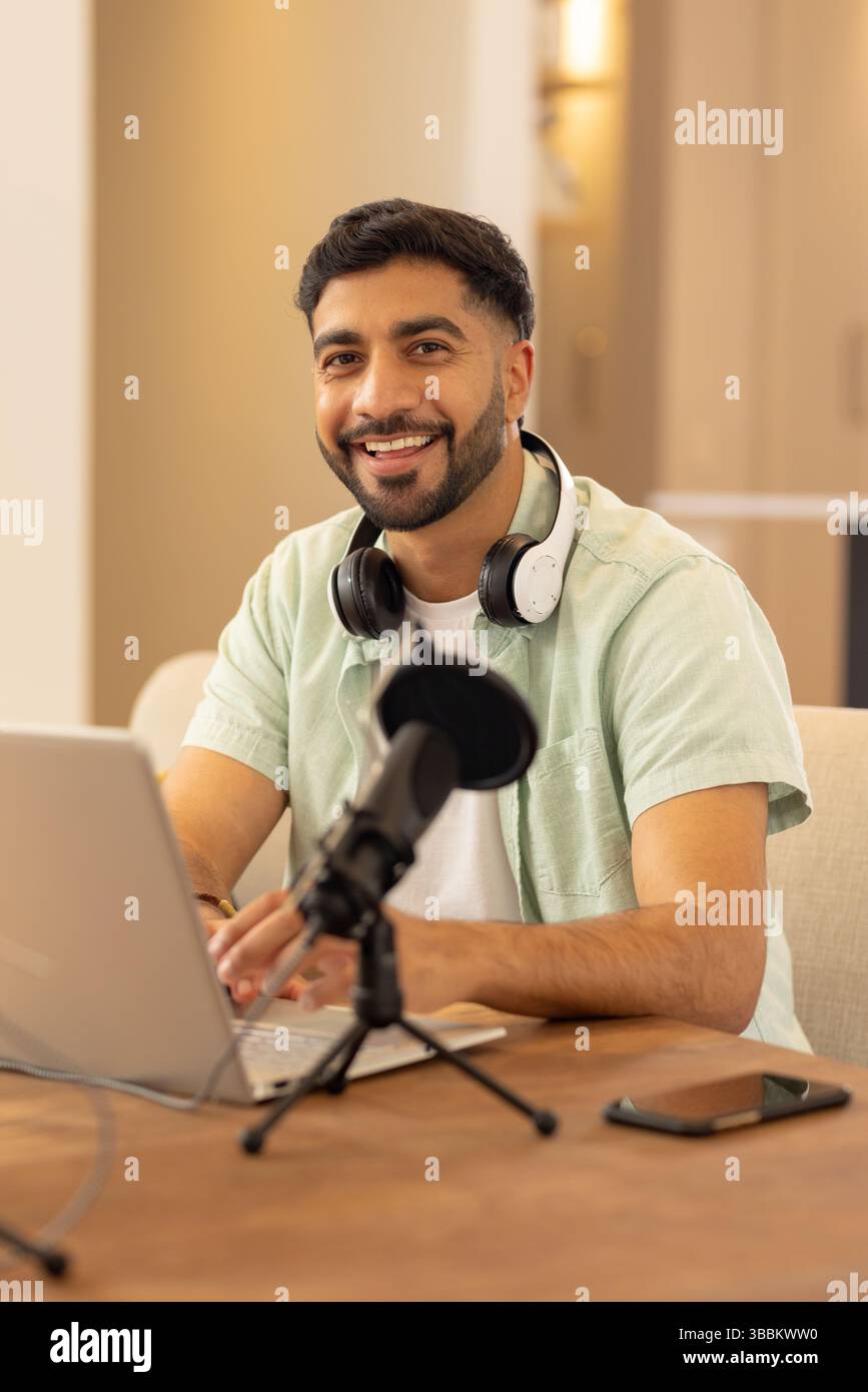 Indian man recording podcast in modern home office, with laptop ...