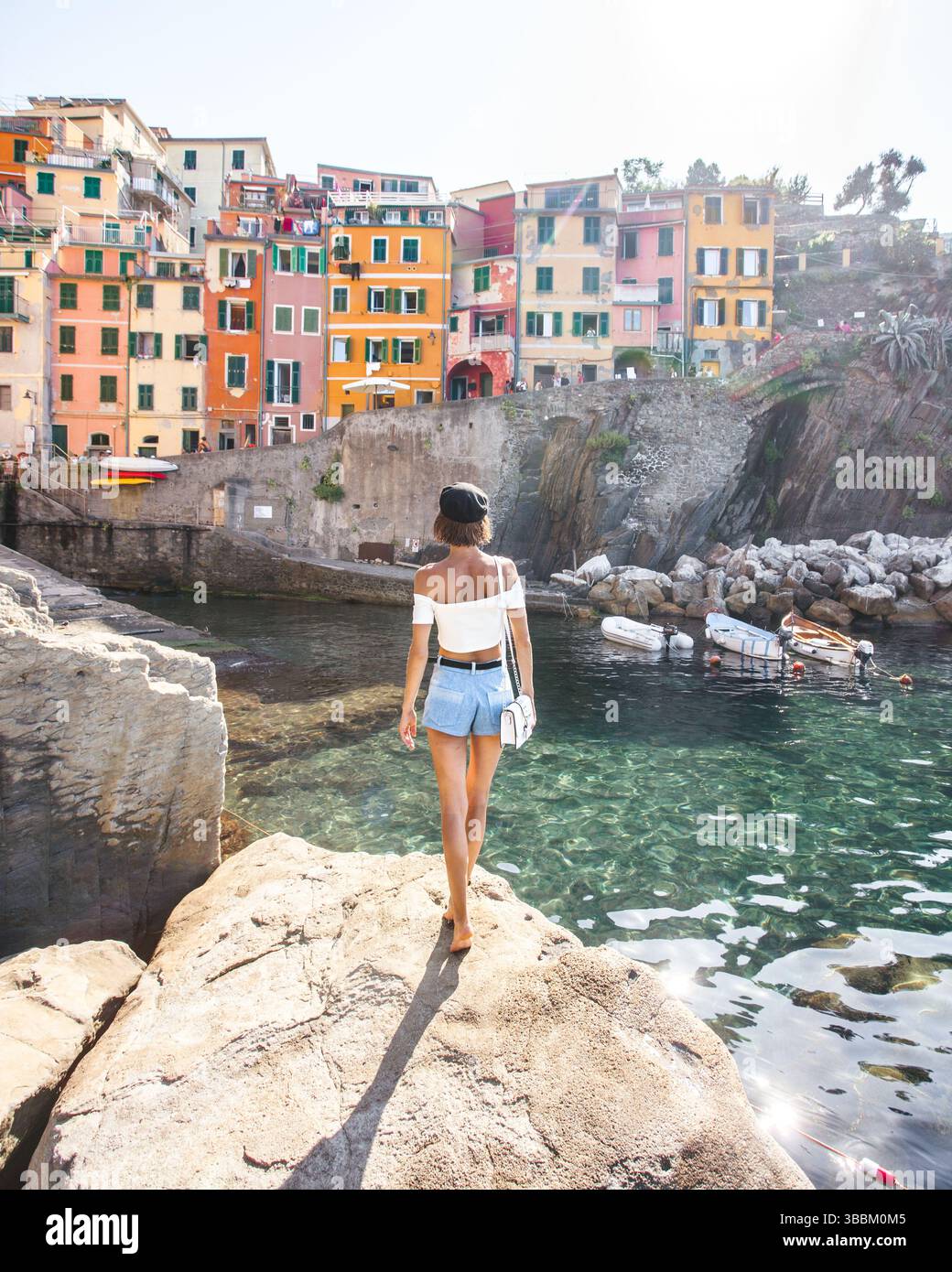 Young woman is standing back to camera and looking at scenic tourist ...