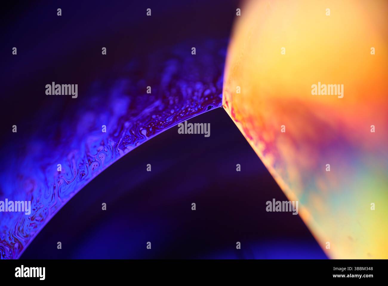 Purple and yellow liquid surface, liquid glass reflection, macro view ...