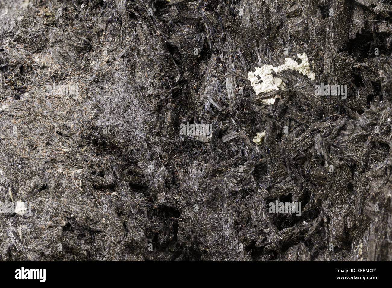 Macro photo of a dark mineral specimen showing fibrous structure and ...