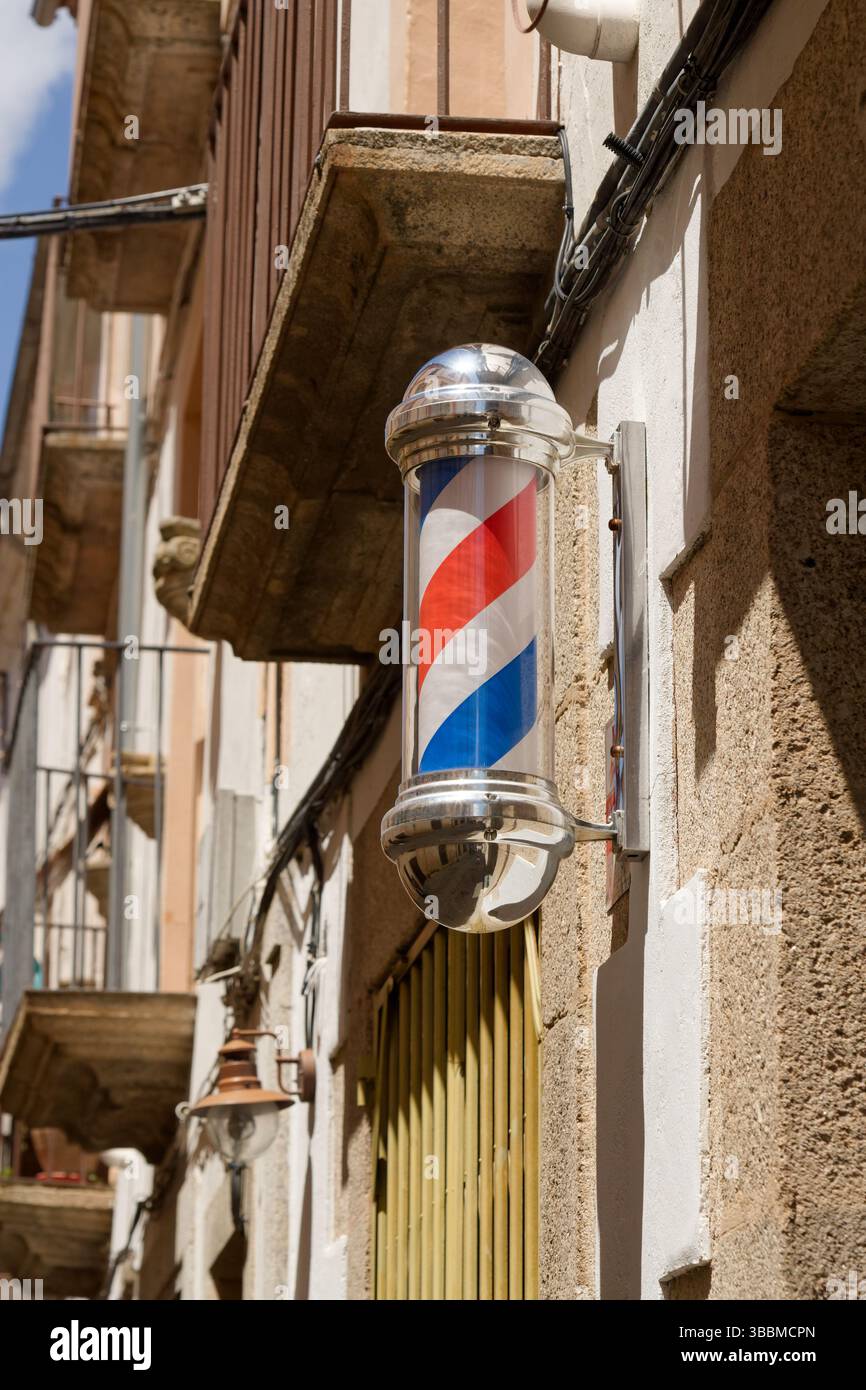 A barbers sign. A rotating barber pole. Advertising. outside ...