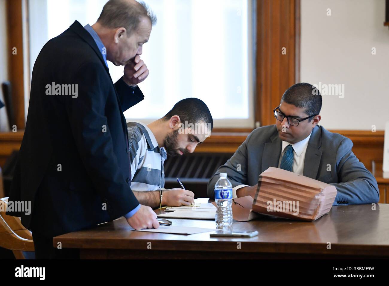 Hadi Matar, center, writes as public defender Nathaniel Barone, left ...