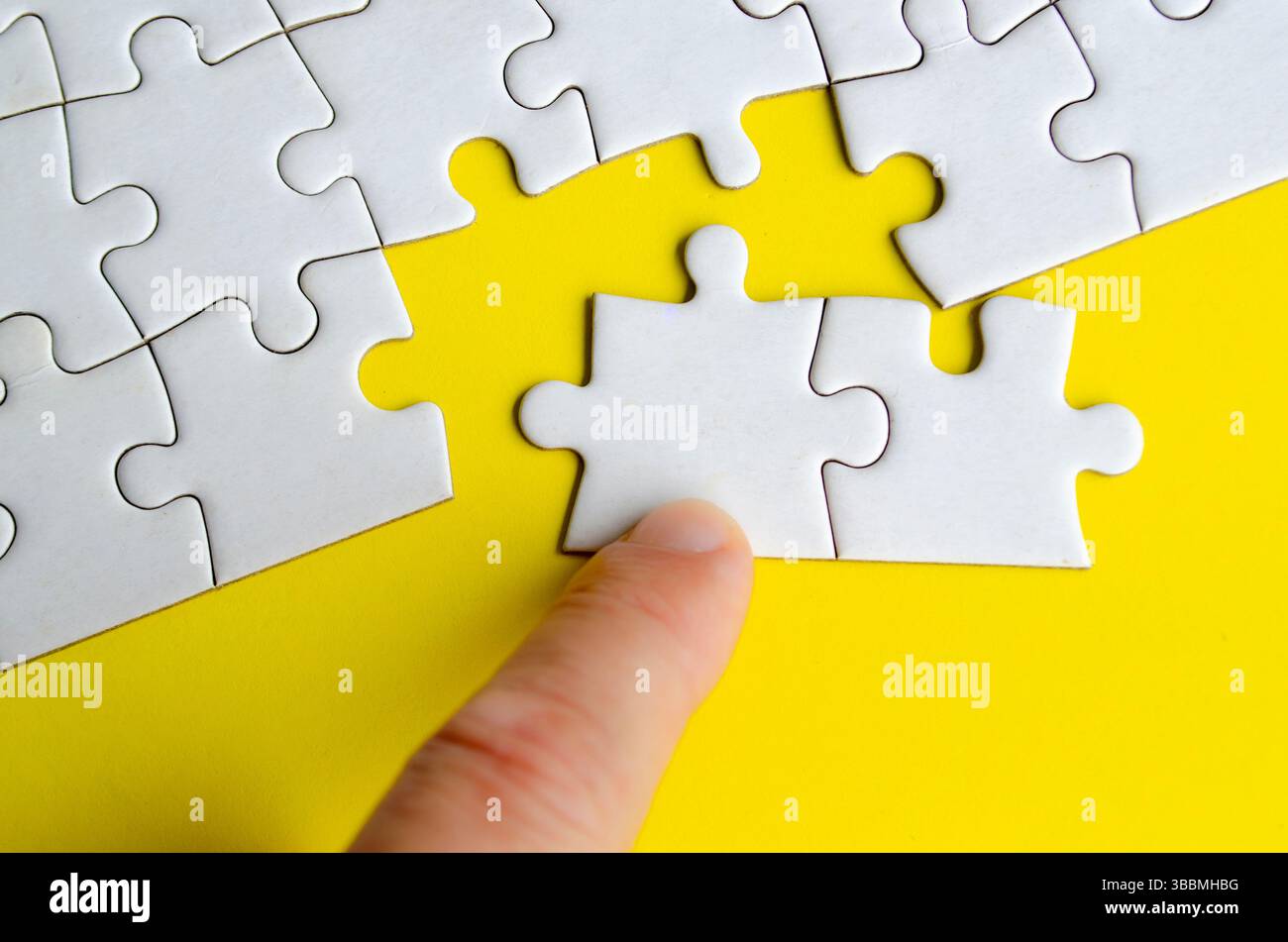 Hand pushing jigsaw puzzle pieces back to its position Stock Photo - Alamy