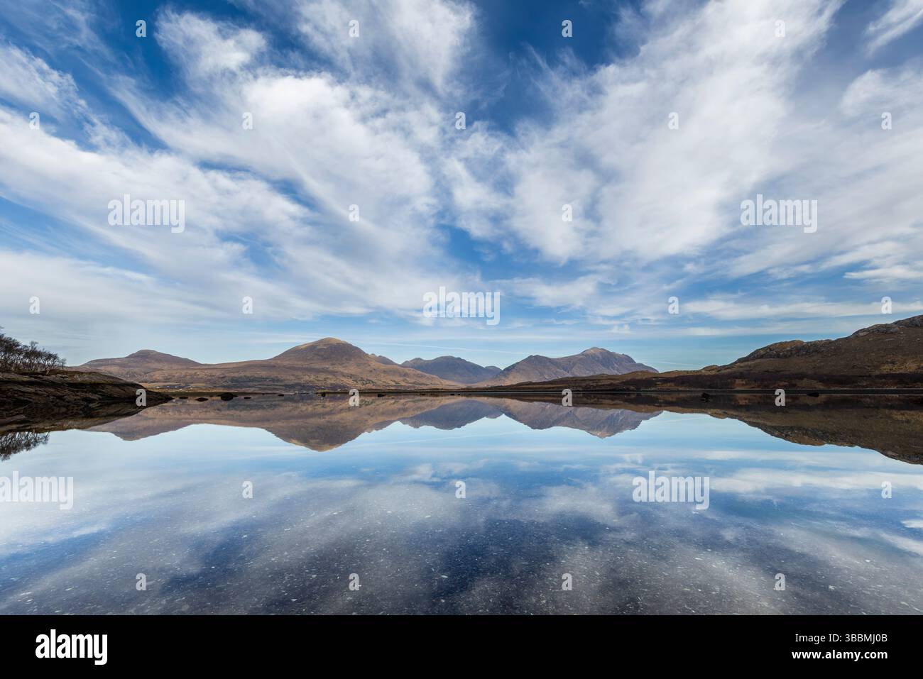 The mountains of Torridon and cirrus clouds reflected in Upper Loch ...