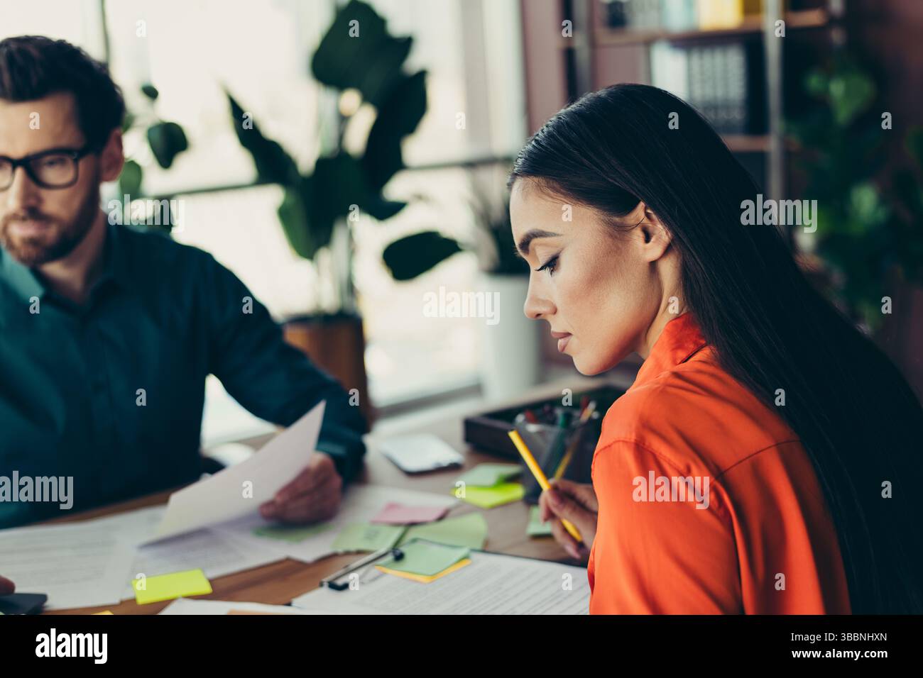 Professionals collaborating in a modern workplace environment, focused ...