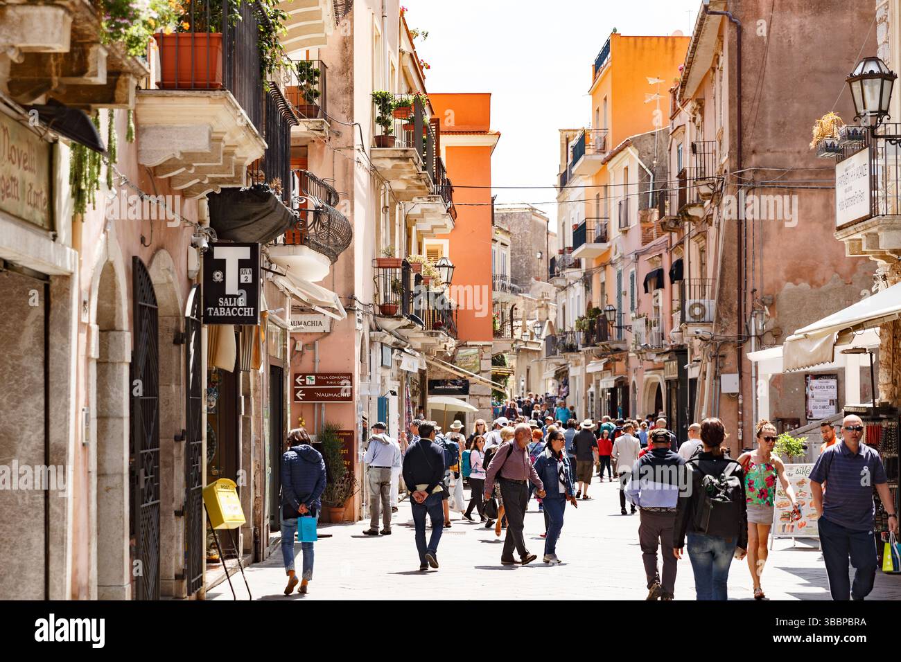 People in crowded sunny street of popular cozy small town Taormina in ...