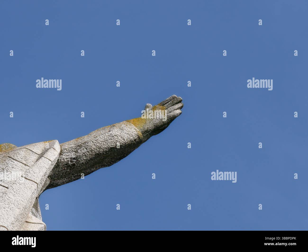 A monumental stone representation features an outstretched arm pointing ...