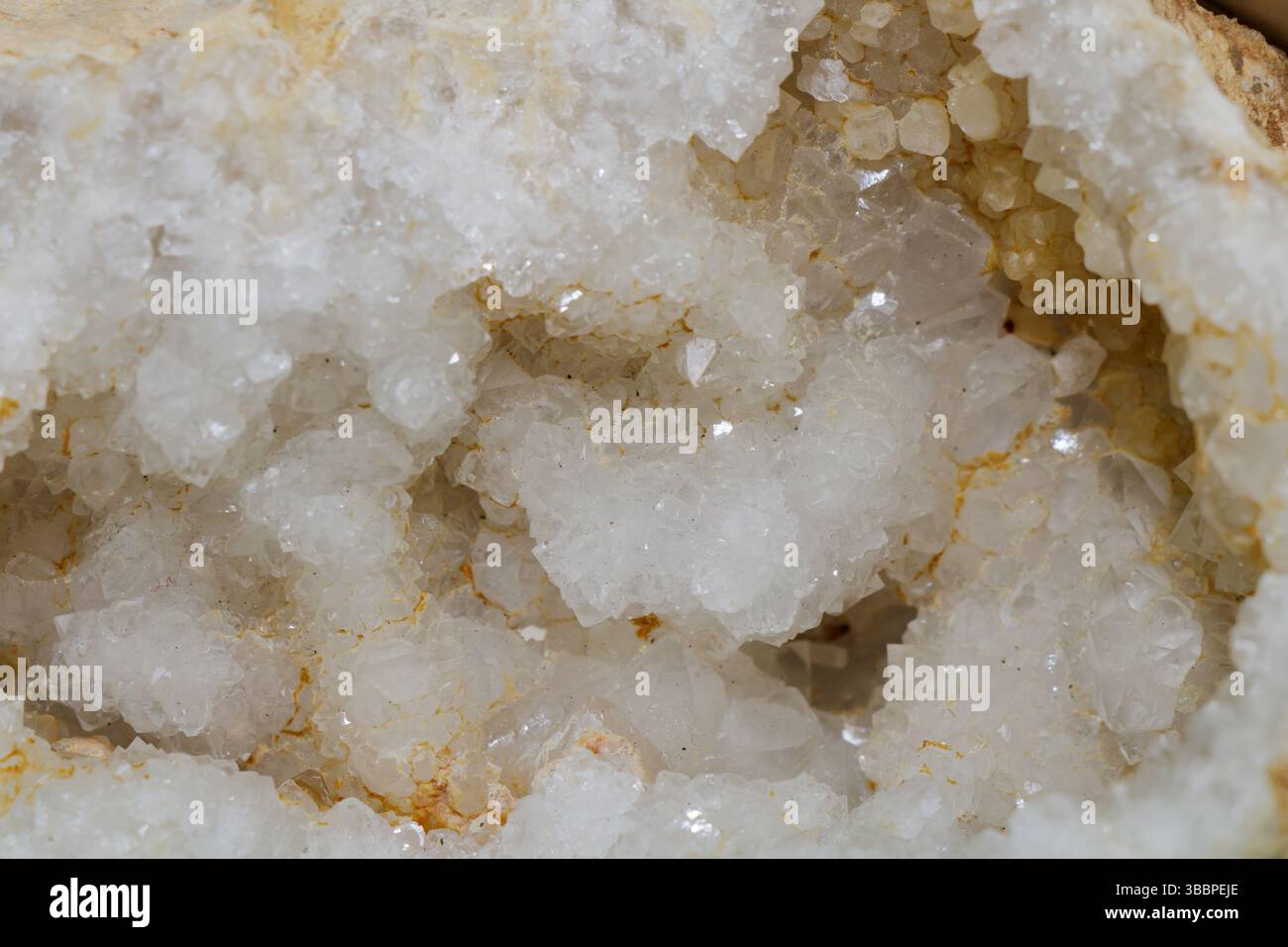 Intricate clusters of clear crystals are visible inside a rock cavity ...