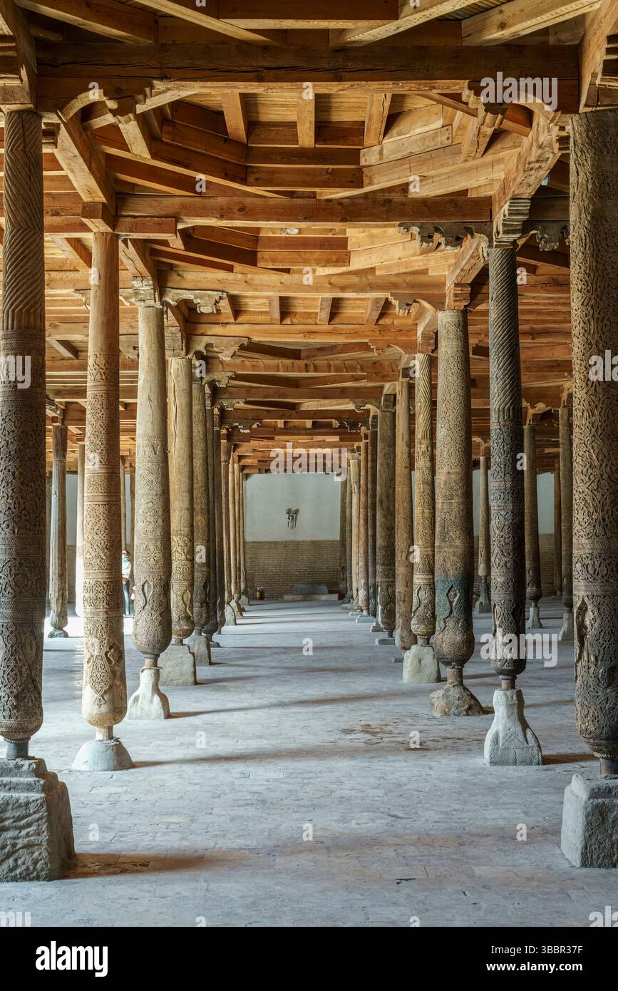 A corridor lined with carved wooden columns creates a rhythmic pattern ...