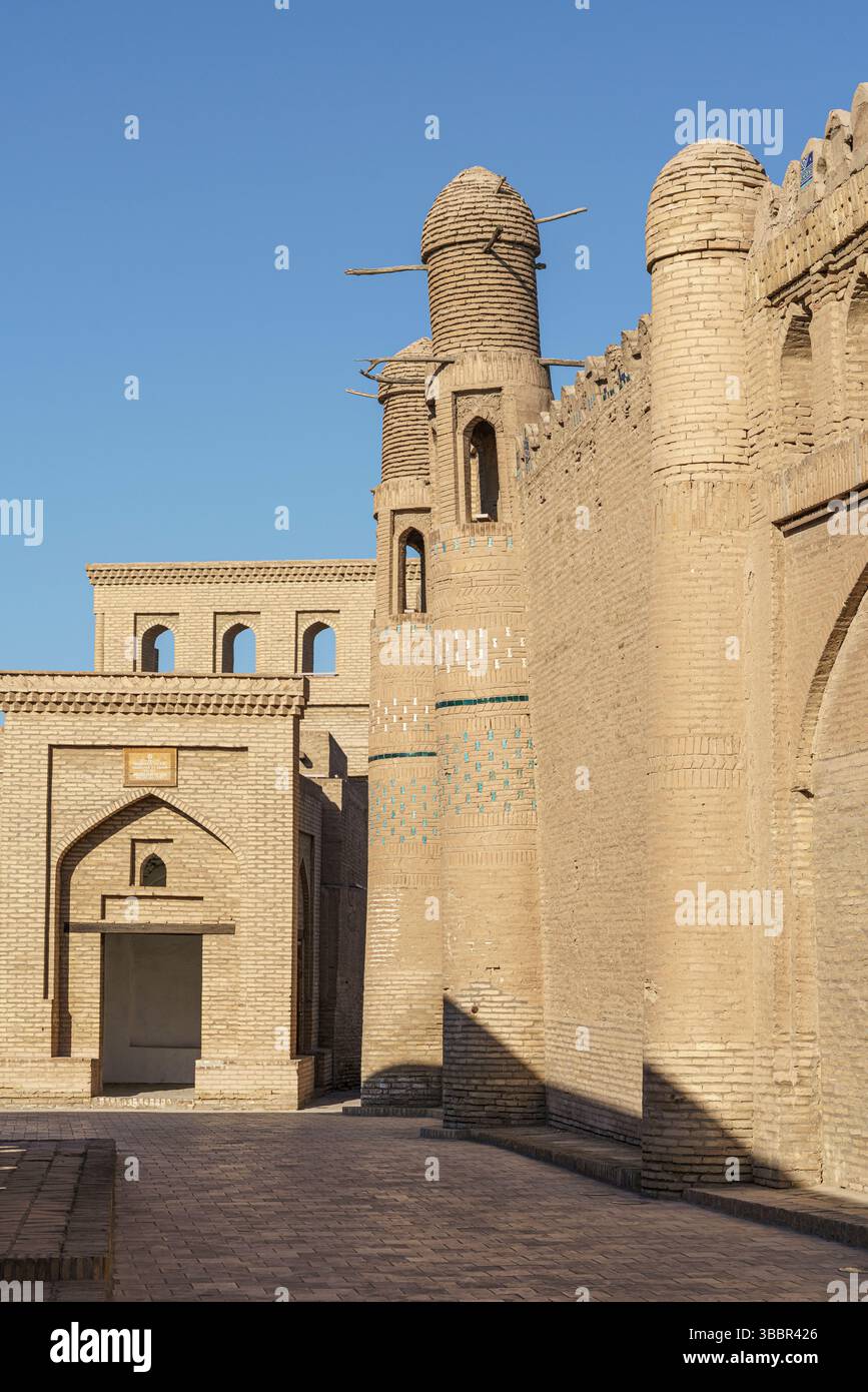 A grand arched entrance with blue tilework and decorative bands marks ...