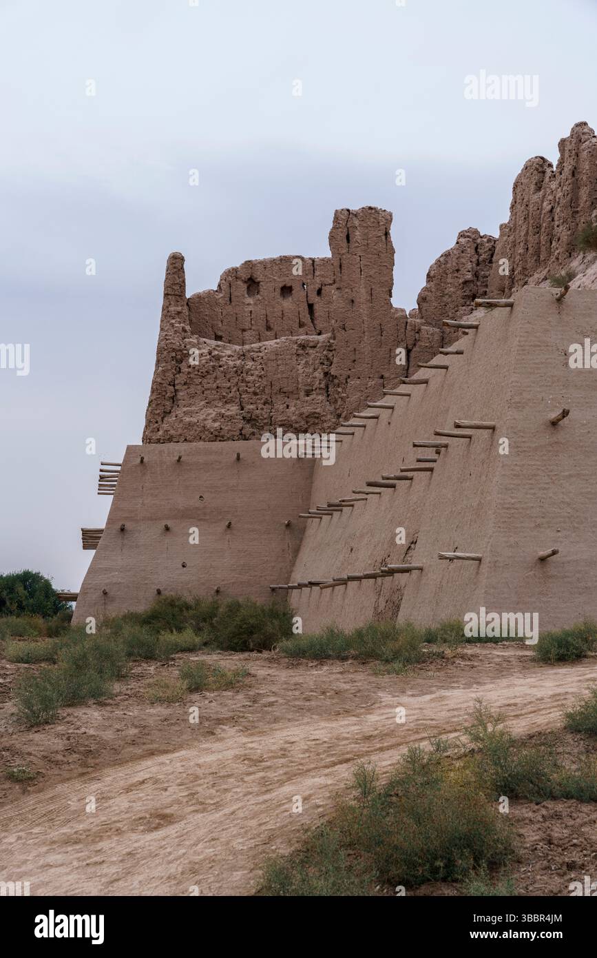 Ruined mudbrick walls with eroded towers rise from the ground at Kizil ...