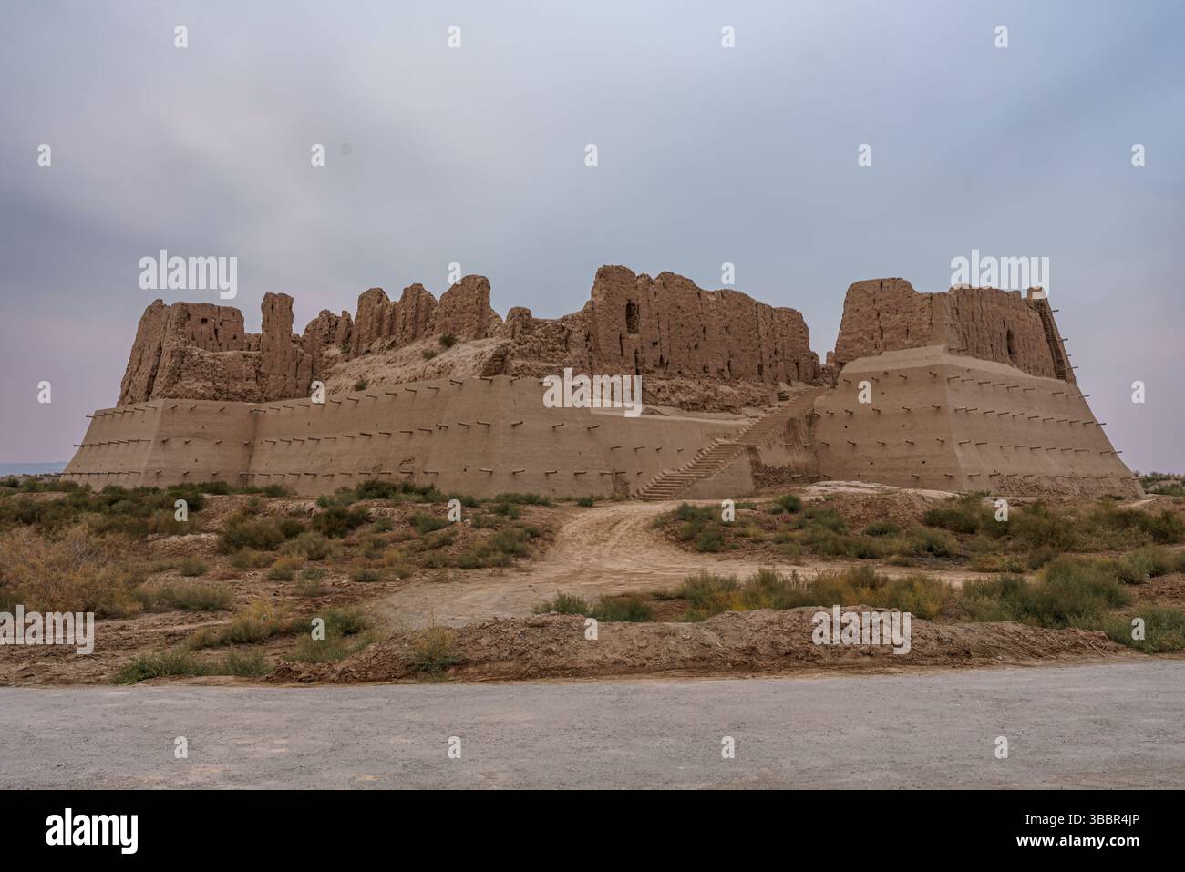 The massive mudbrick walls of Kizil Kala fortress rise above the plain ...