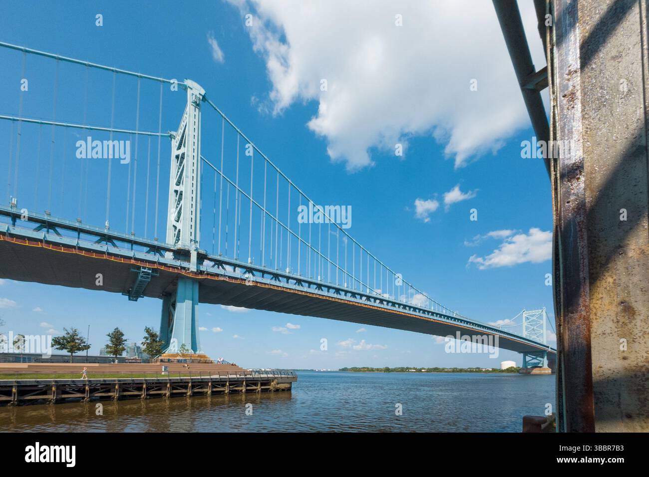 Benjamin Franklin bridge spans a body of water, with a blue sky above ...