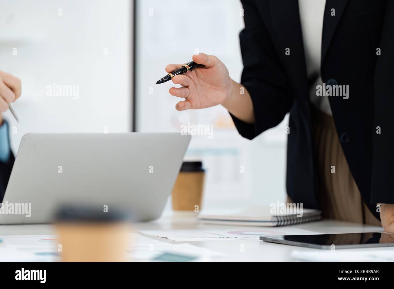 Business professional presenting ideas with a pen during a ...