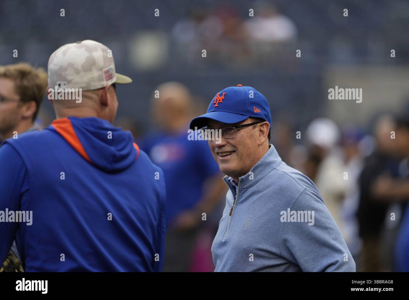 New York Mets owner Steve Cohen talks with people on the field before a ...