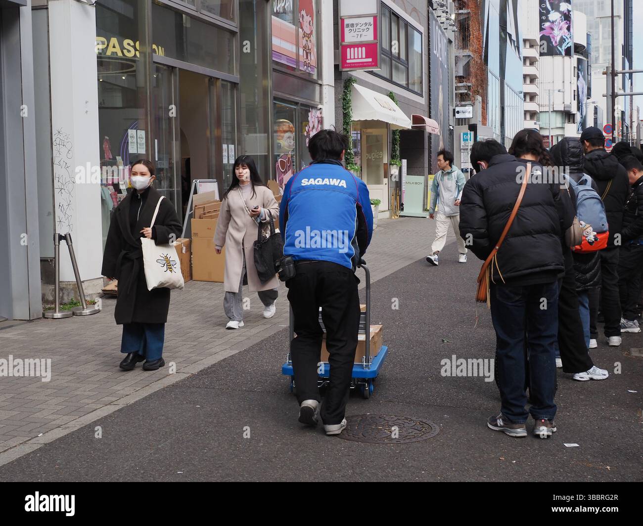 TOKYO, JAPAN - February 18, 2025: Street with a Sagawa delivery worker ...