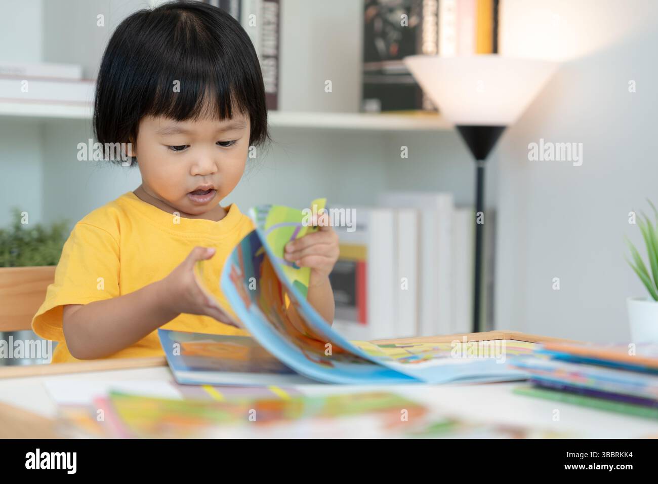 Happy Asian children relax read book at home. daughter and reading a ...
