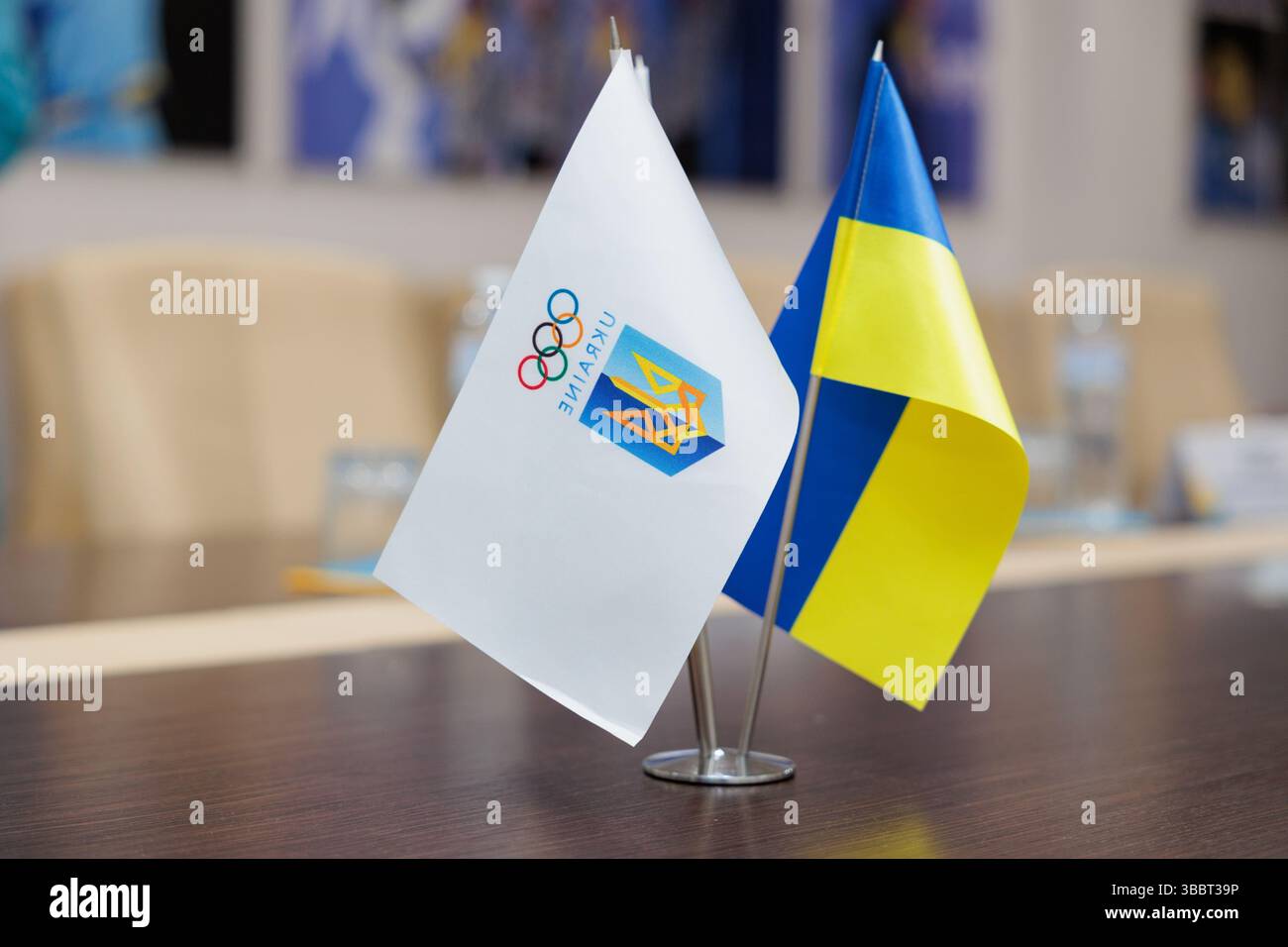 Ukrainian flag and Olympic Committee flag stand on a table during a ...