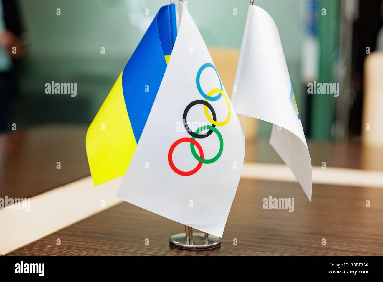 Ukrainian flag and Olympic Committee flag stand on a table during a ...