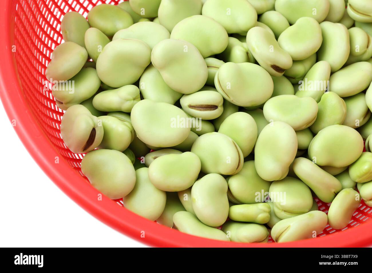 stack of broad beans in a basket on white background Stock Photo - Alamy