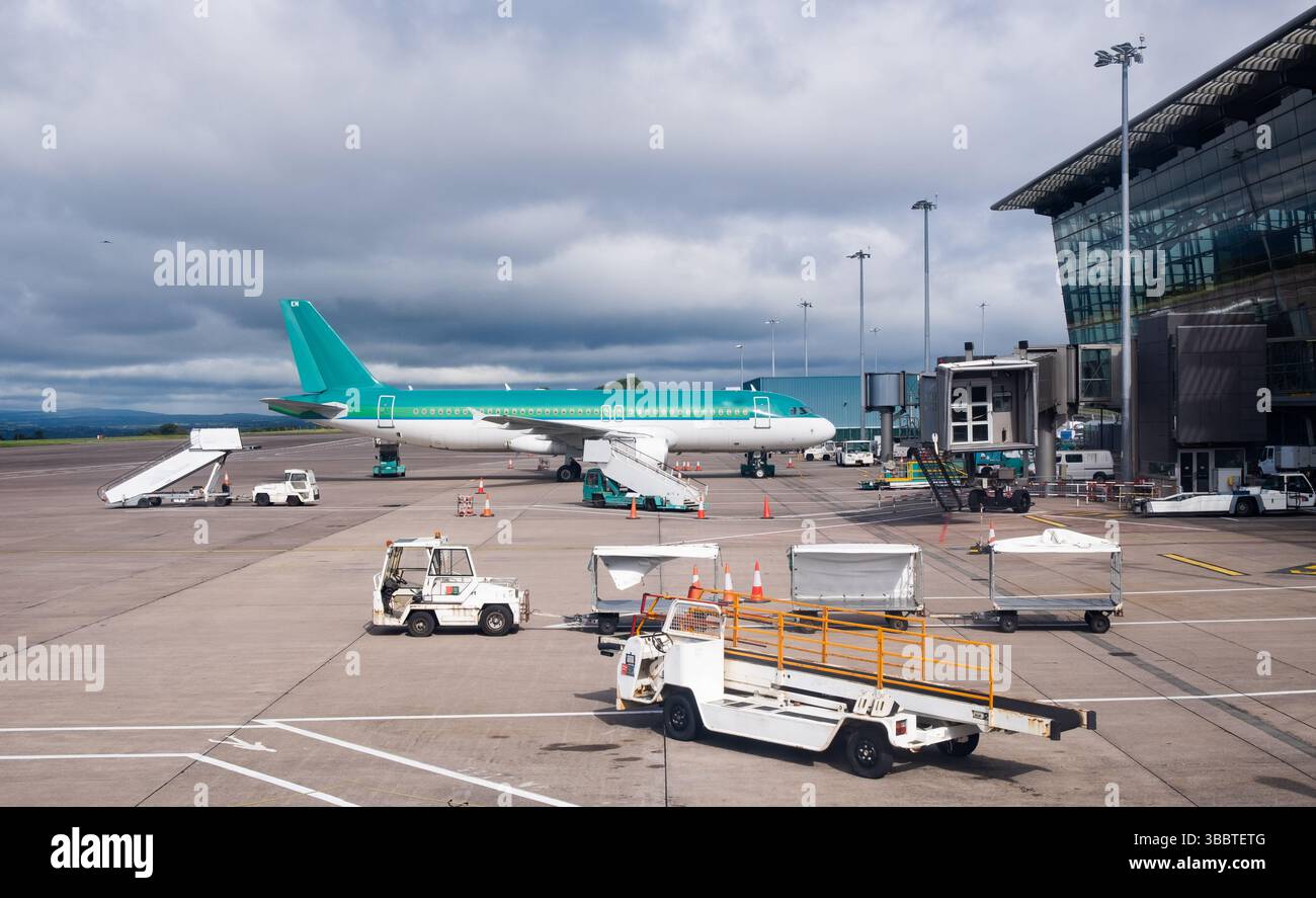 Airplane on the departure runway in a modern airport and cargo vehicles ...