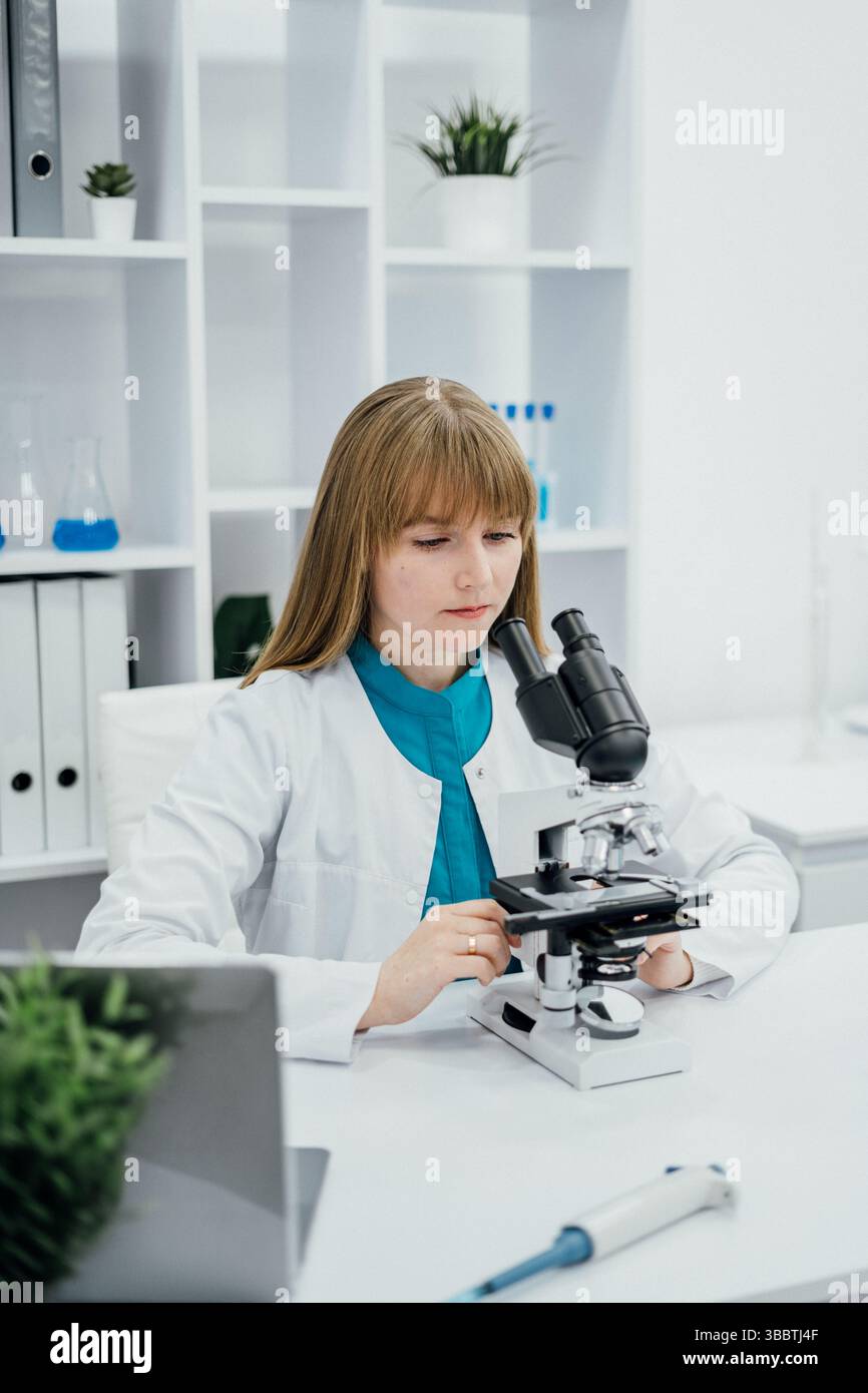 Female scientist examines biological sample through digital microscope ...
