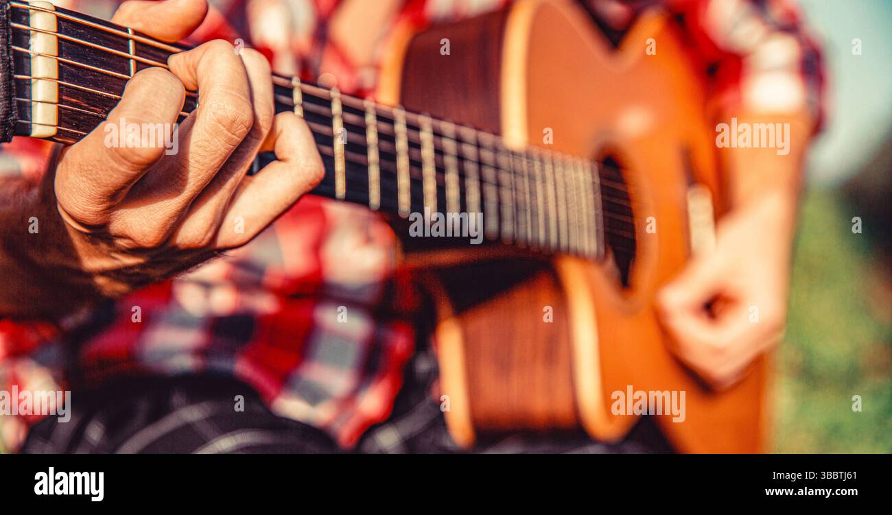 Close-up of a musician s hands playing an acoustic guitar. A male ...