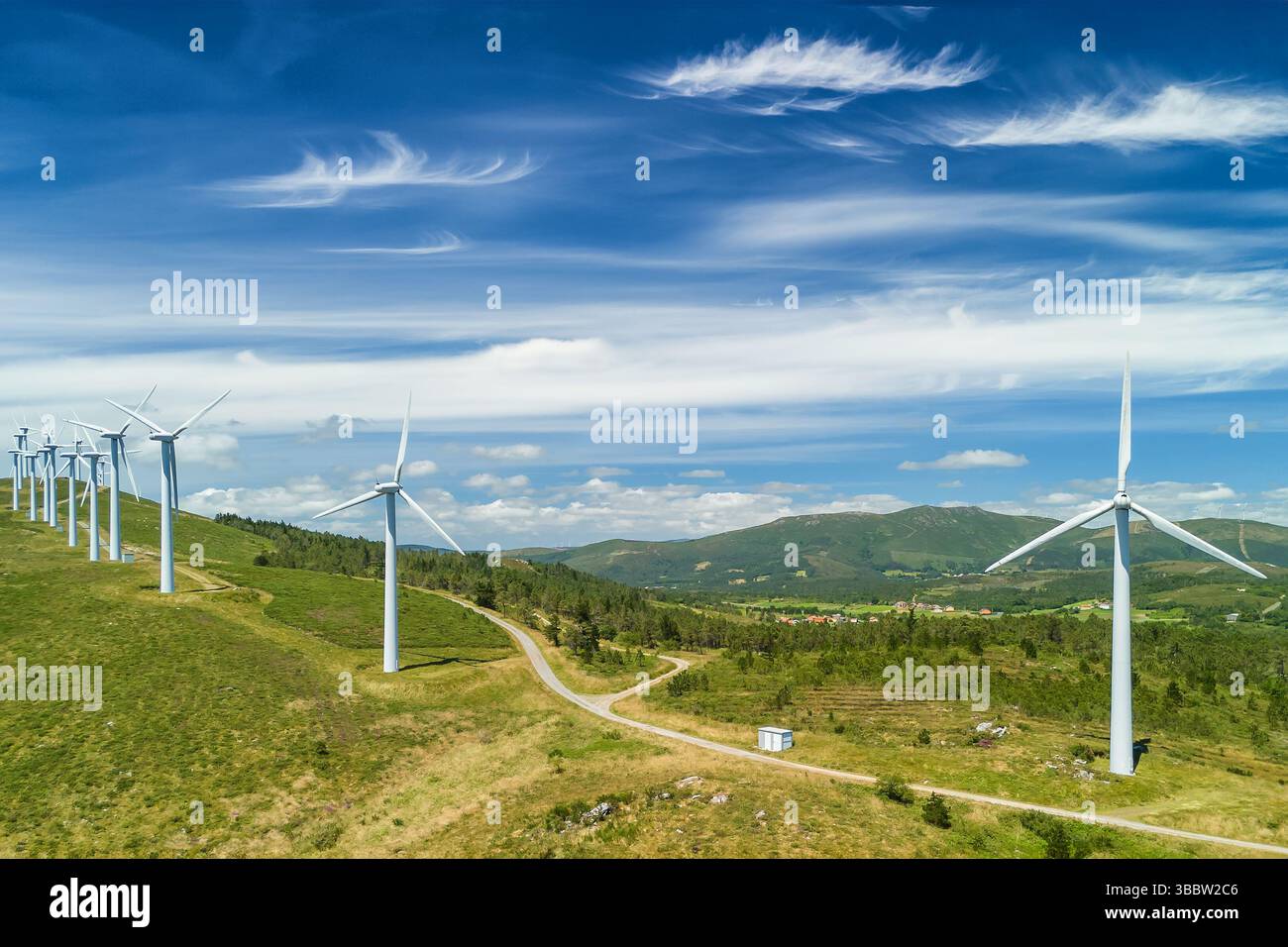 Aerial view of large wind turbines with spinning blades on top of a ...