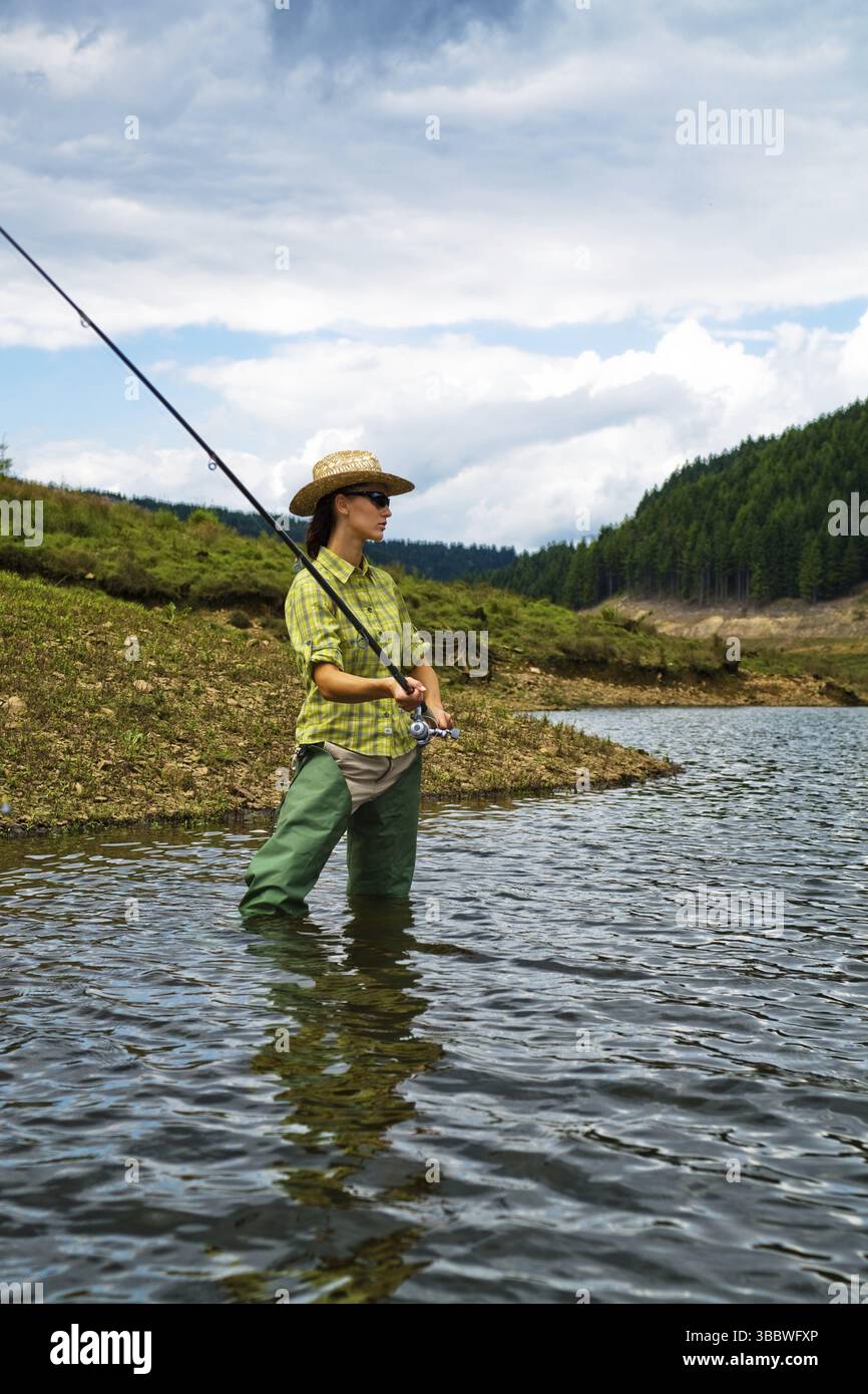 A female angler fishing in the river Stock Photo - Alamy