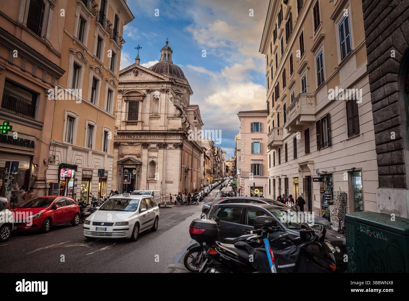 ROME, ITALY - JANUARY 15, 2025: Traffic and parked scooters line Via ...