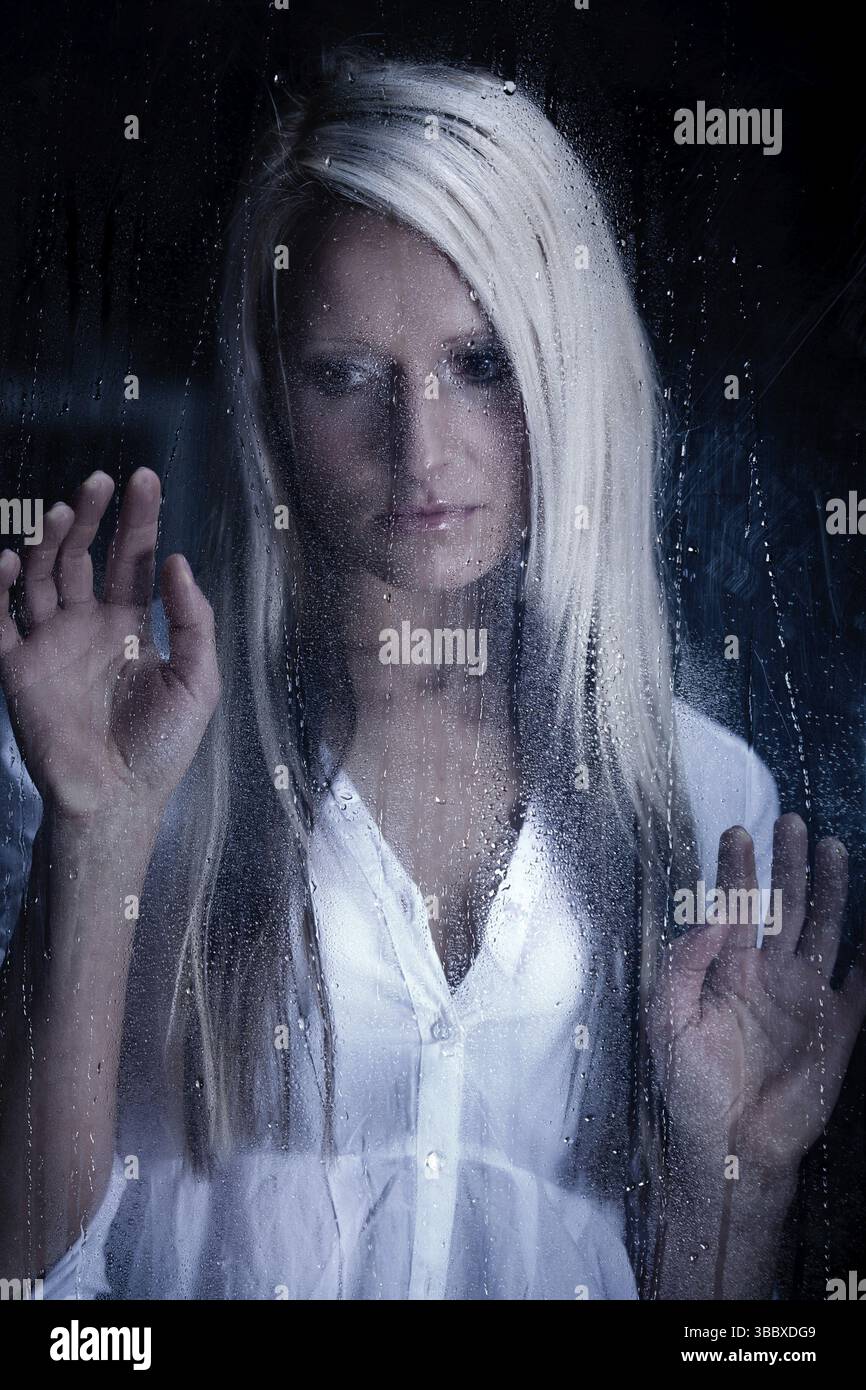 Portrait of the young woman behind a rainy window Stock Photo - Alamy
