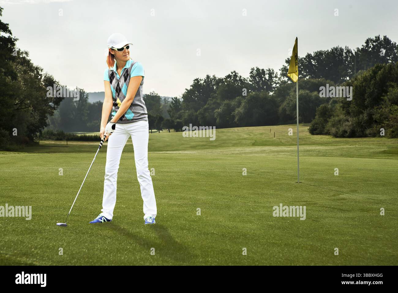 Female golf player with a golf club on the course Stock Photo - Alamy