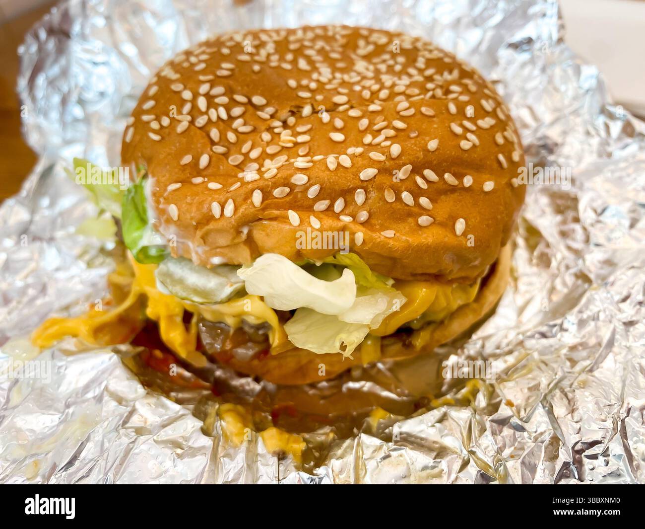 A cheeseburger on it's foil wrapper in a fast food restaurant Stock ...