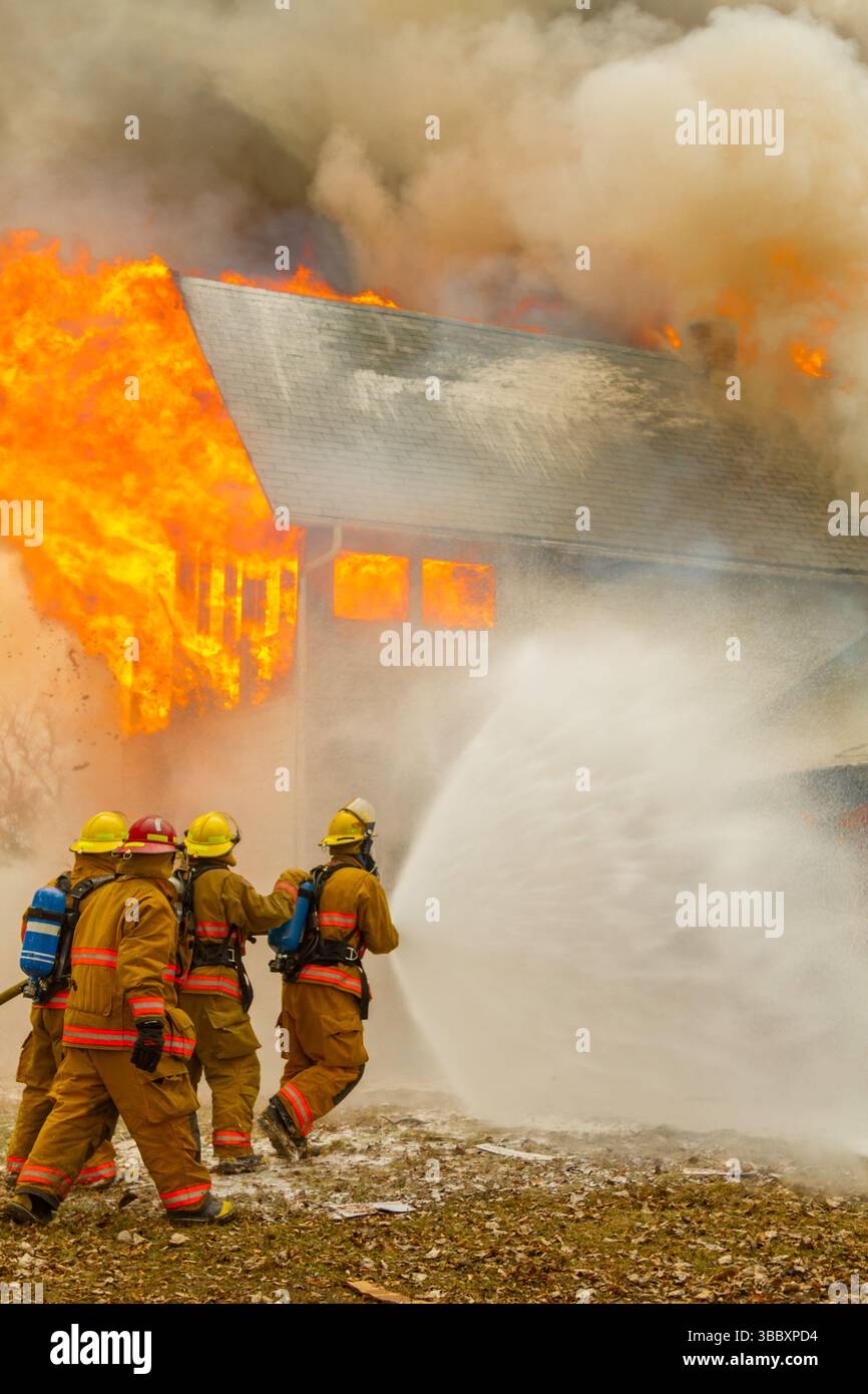 four firefighters advancing on a fire Stock Photo - Alamy