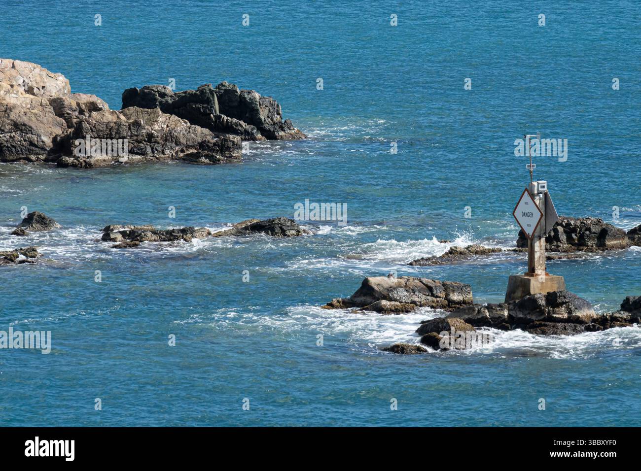Sign warning of dangerous rocks in seaport entrance Stock Photo - Alamy