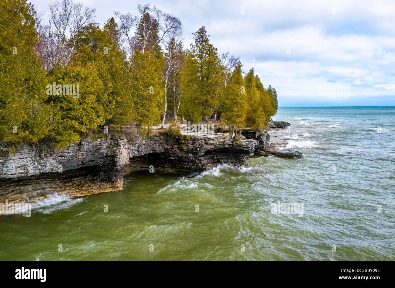 View from the water showing the rugged limestone cliffs and rocky ...