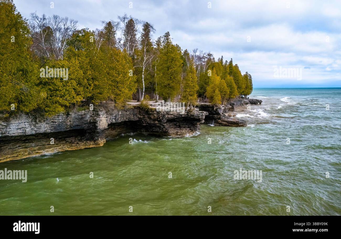 View from the water showing the rugged limestone cliffs and rocky ...