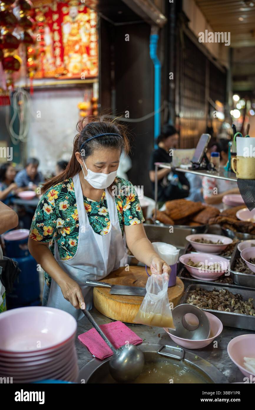 Thai woman wearing face mask cooking local food at food stall at ...