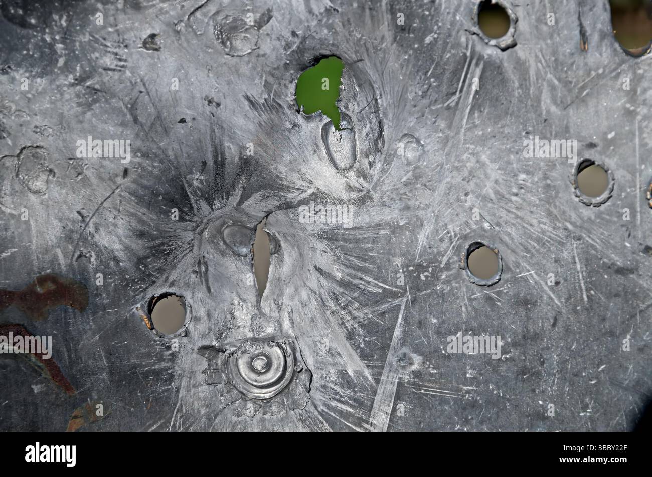 Bullet holes of different calibers on piece of sheet steel after ...